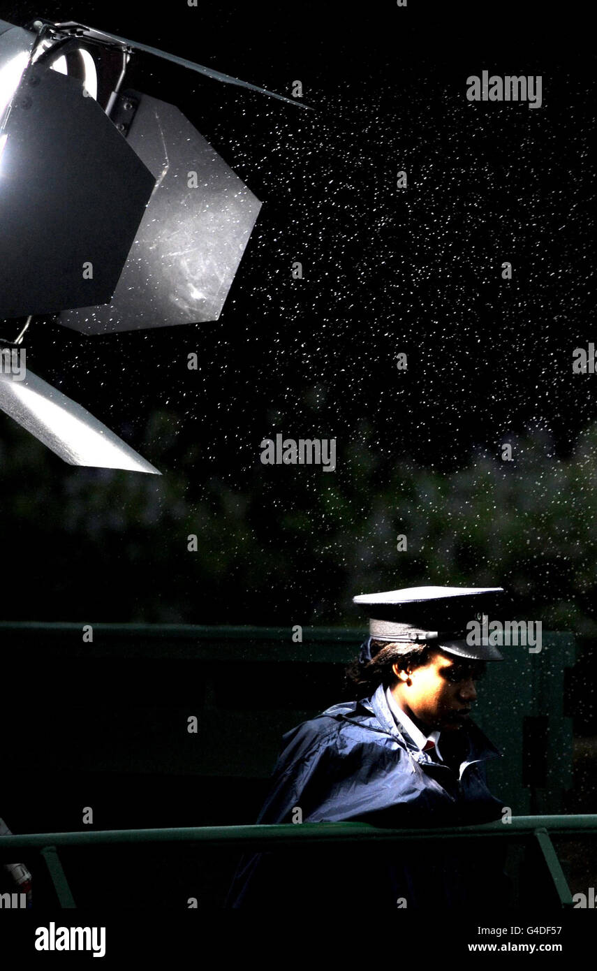 A security guard stands in driving rain on the roof of the broadcast ...