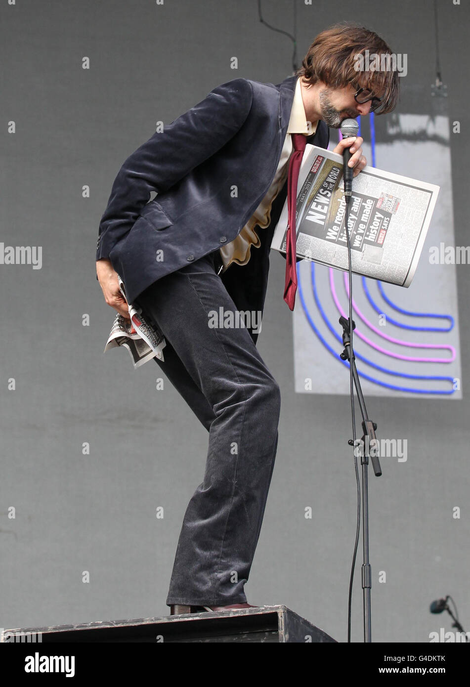 Jarvis Cocker from Pulp holds a copy of the News of the World newspaper ...