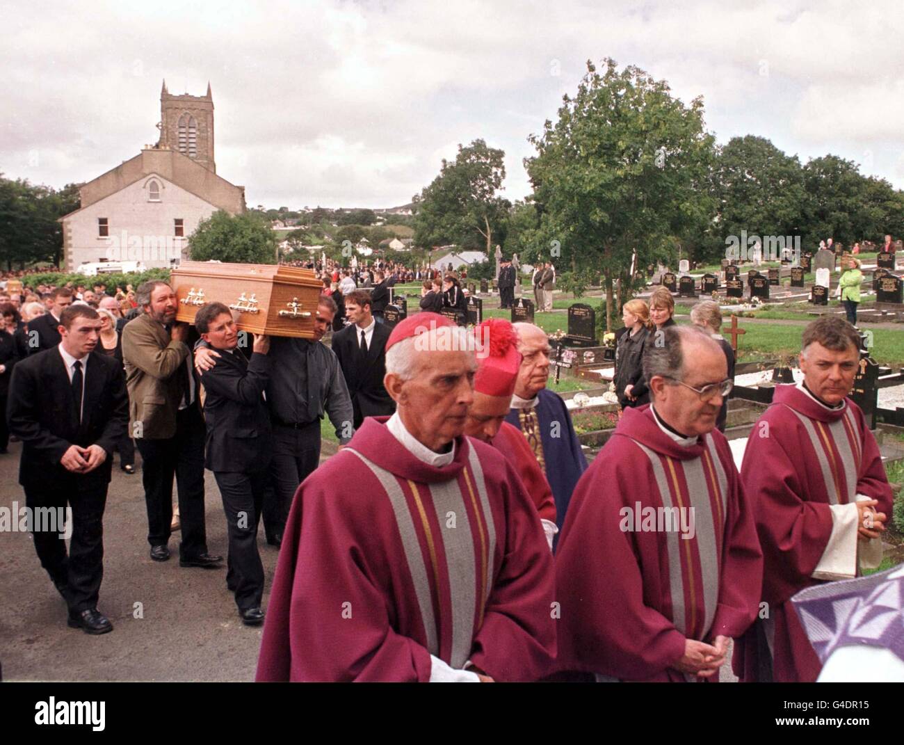 Priests lead the procession of coffins, carrying James Barker and Sean ...