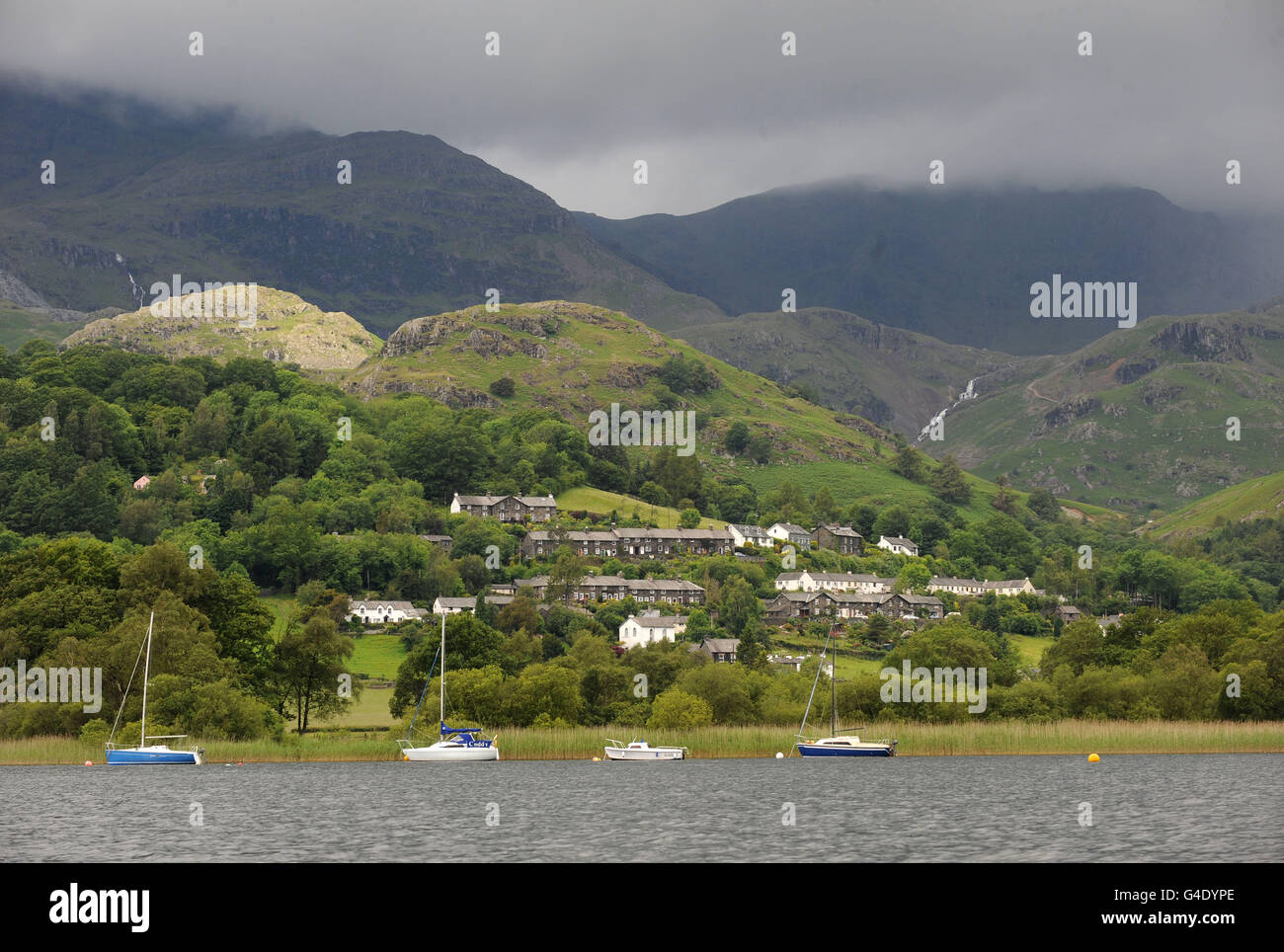 A general view showing Coniston village and fells from Lake Coniston in ...