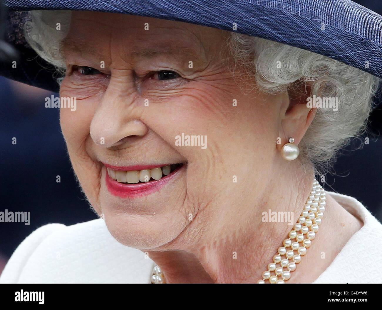 Queen Elizabeth II smiles whilst speaking to guests at a garden party ...