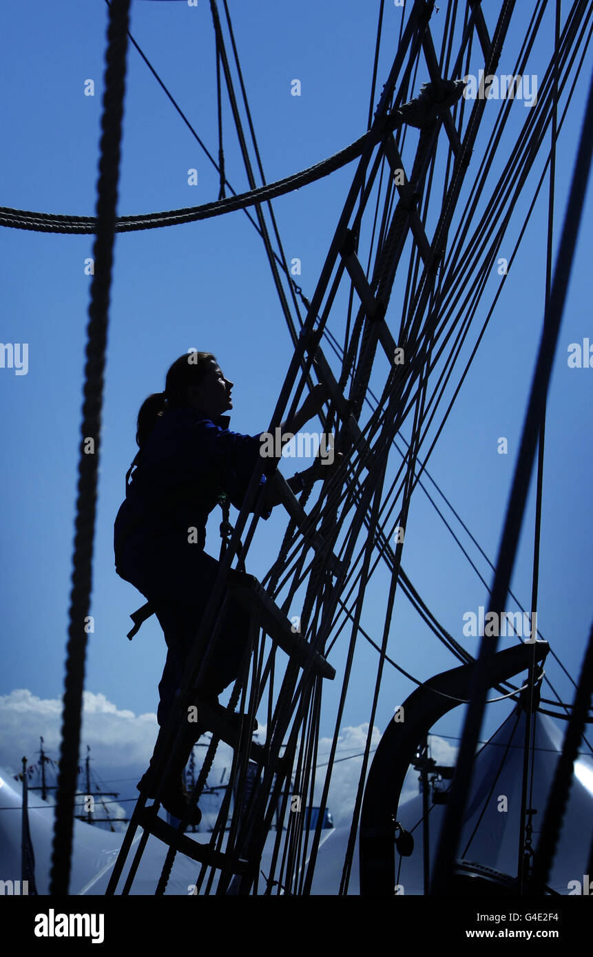 A crew member checks the rigging onboard one of the tall ships taking ...