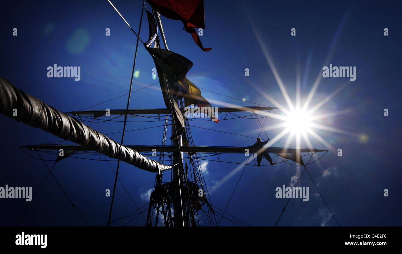 A crew member checks the rigging onboard one of the tall ships taking ...