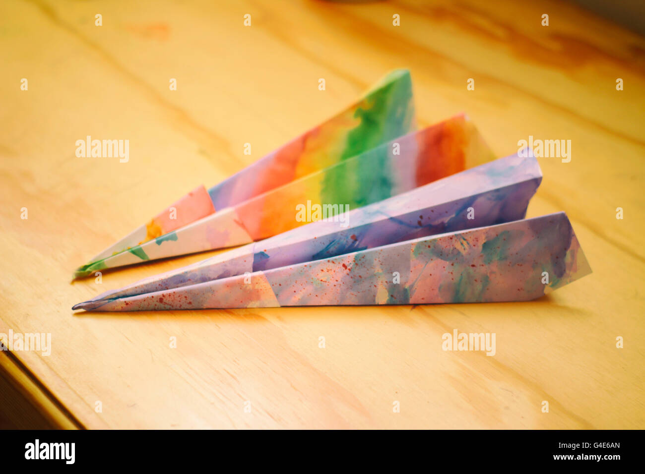 Photograph of some paper colorful planes on a wood table Stock Photo ...