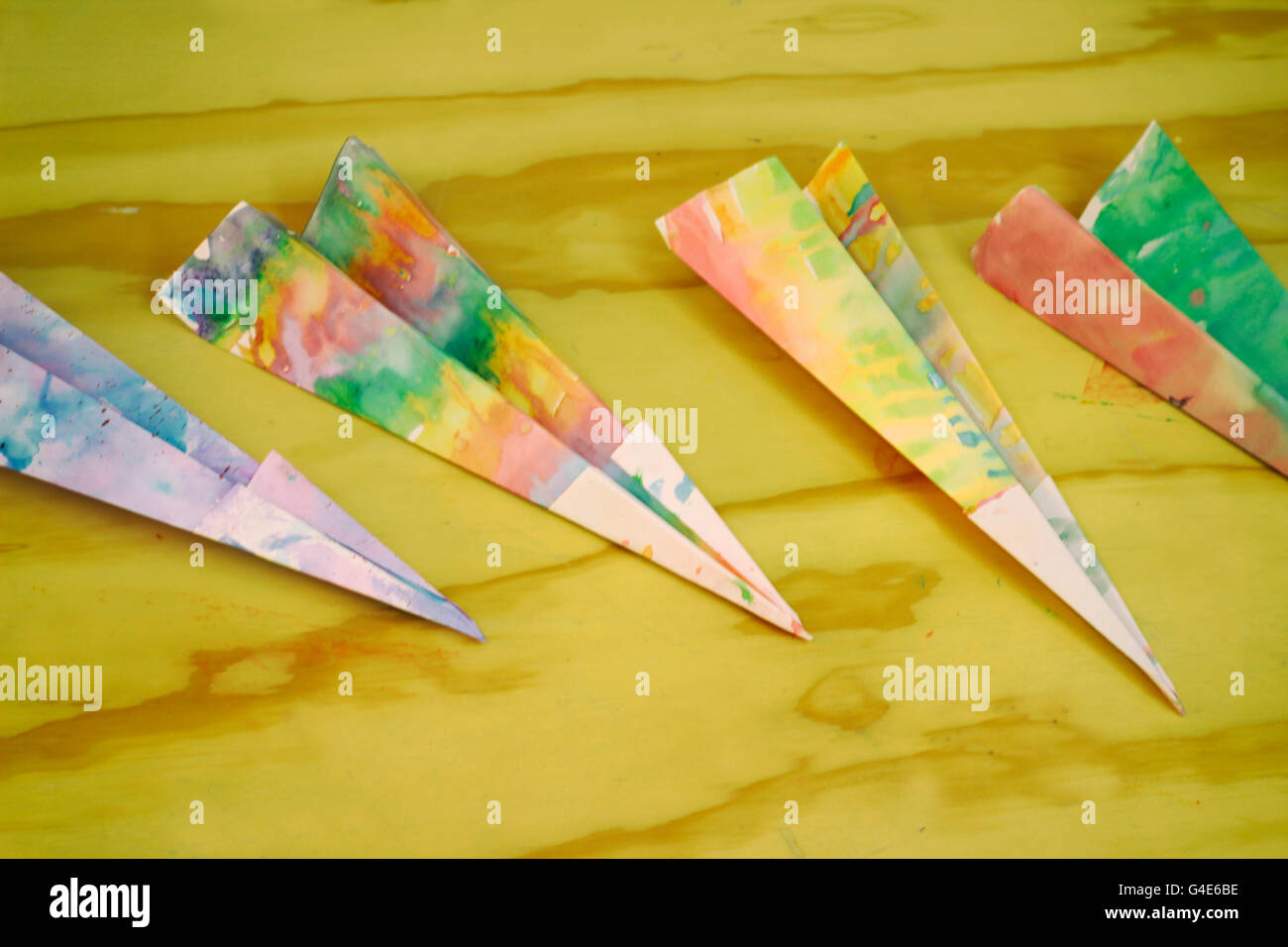 Photograph of some paper colorful planes on a wood table Stock Photo ...