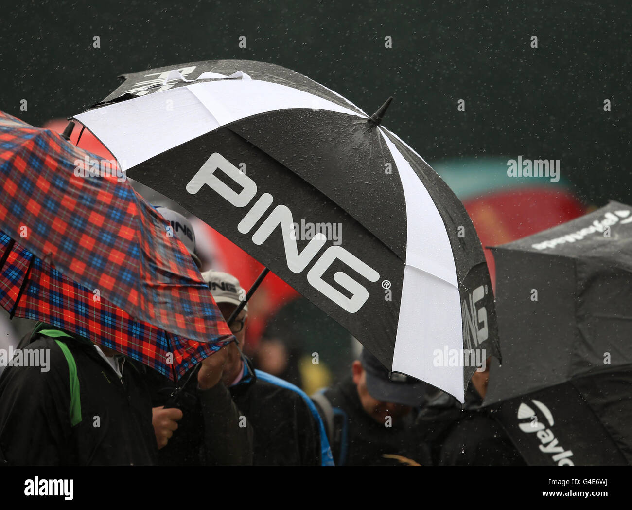 A spectator holds a PING umbrella during round three of the 2011 Open ...