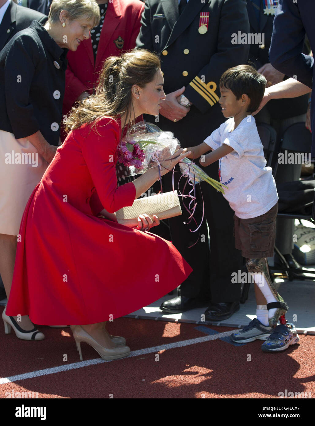 The Duchess of Cambridge receives flowers from Samuel Seehawer during a ...