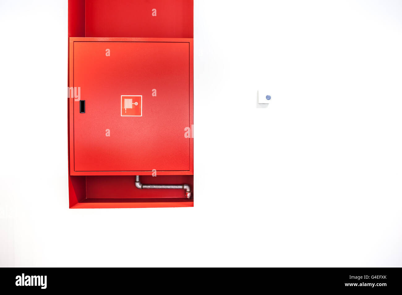 an fire hose hanging on the wall Stock Photo - Alamy