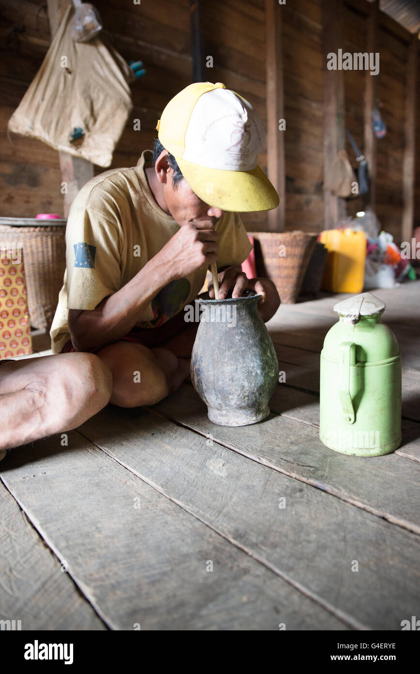 A Kayaw (Bwe) man drinking homemade rice wine with a straw, Yosapra ...