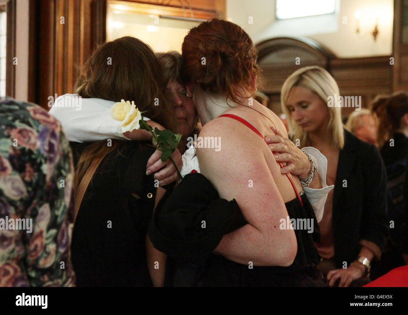 People console each other after a service of prayer and reflection ...