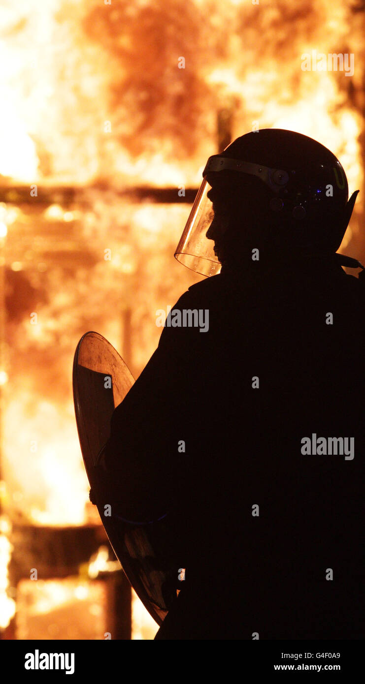 Riot police look on as fire rages through a building in Tottenham ...