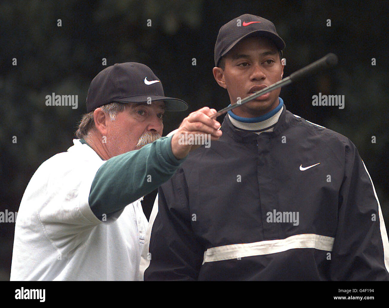 American golfer Tiger Woods listens to caddie Mike "Fluff" Covan, as he ...