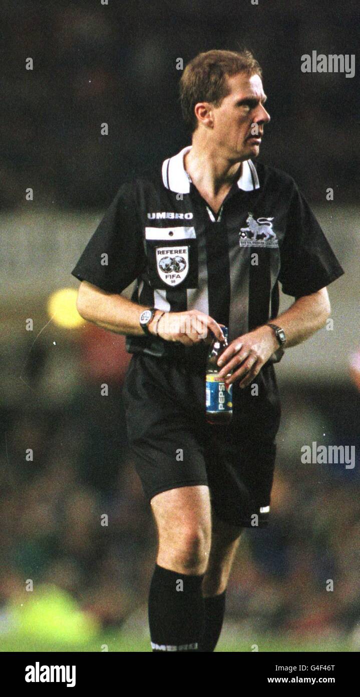 Referee Peter Jones carries a bottle from the pitch after this ...