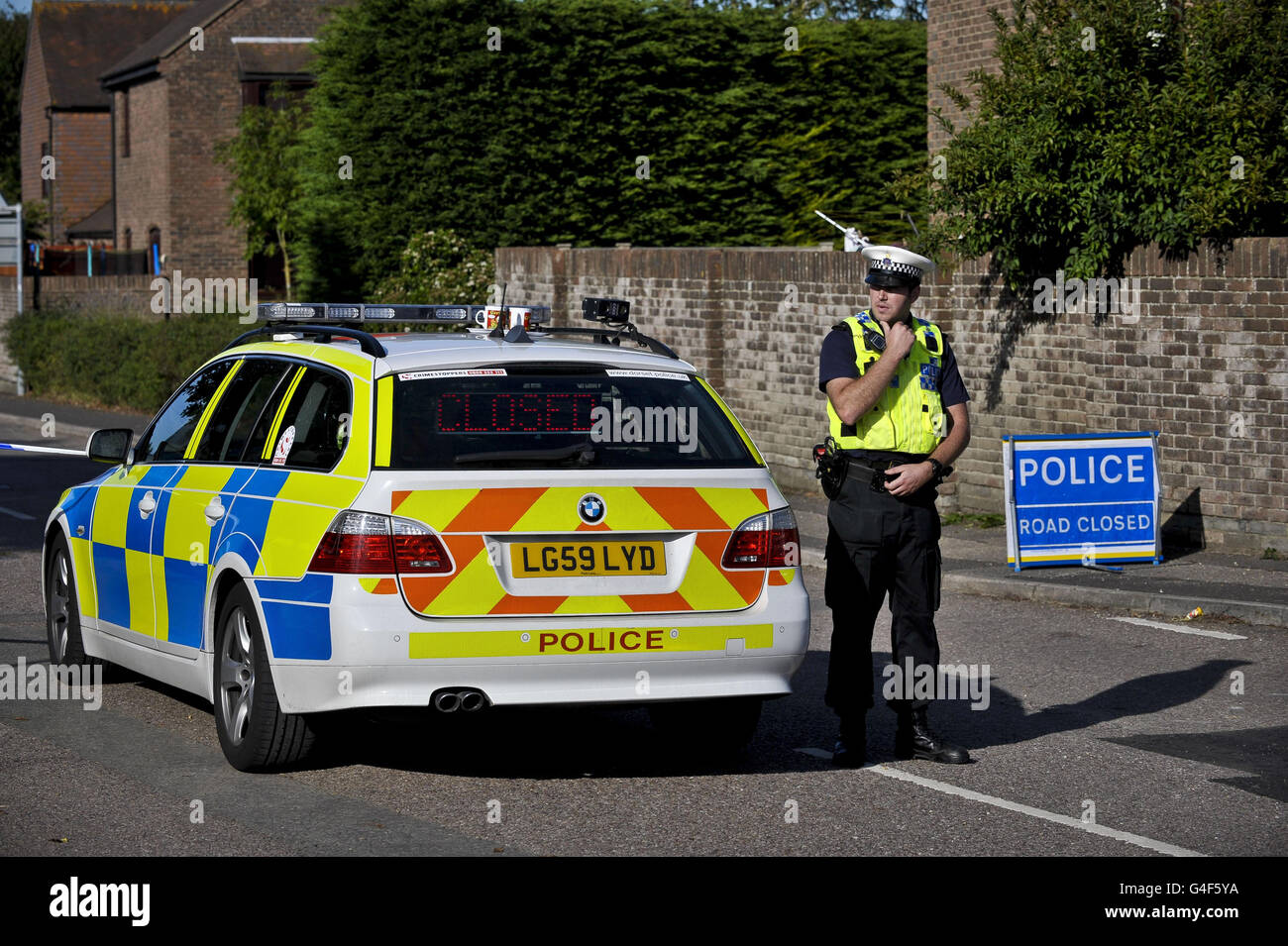 Police cordon off a road leading to fields near the village of Throop ...