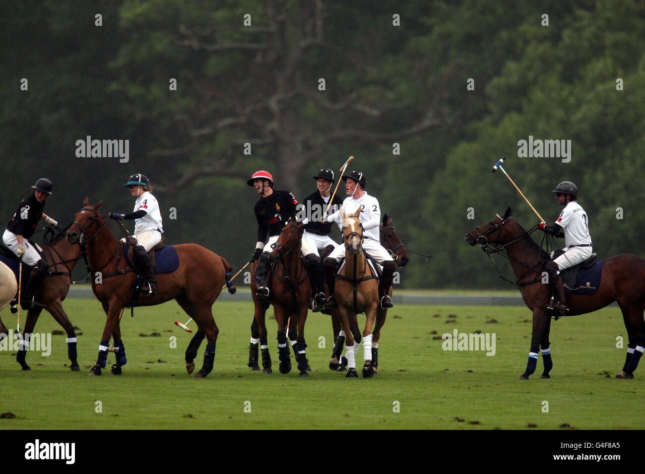 The Duke of Cambridge and Prince Harry (C) play in the Sentebale Polo ...