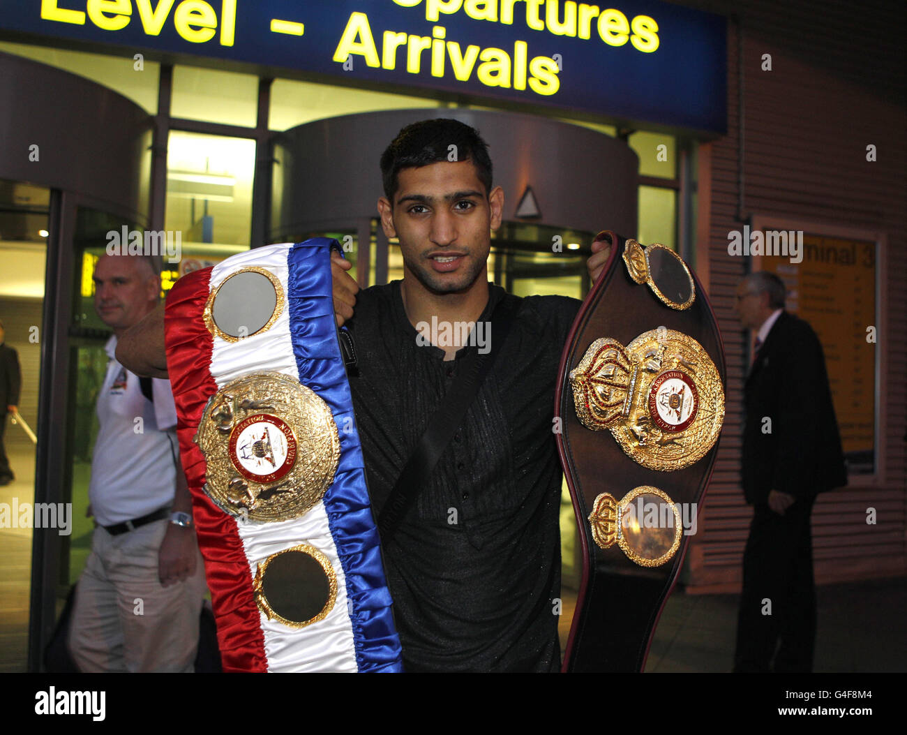 Amir Khan poses with his belts after arriving back at Manchester ...