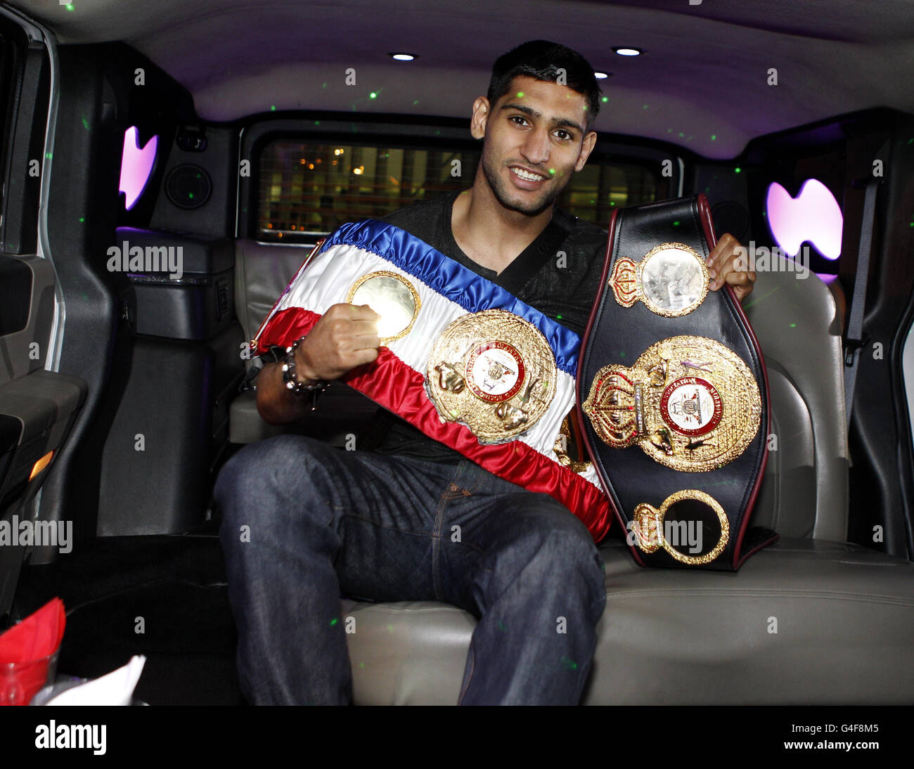 Amir Khan poses with his belts after arriving back at Manchester ...