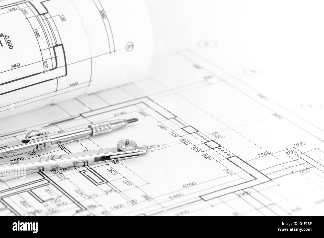 floor plan with rolled blueprint and drawing compass Stock Photo - Alamy