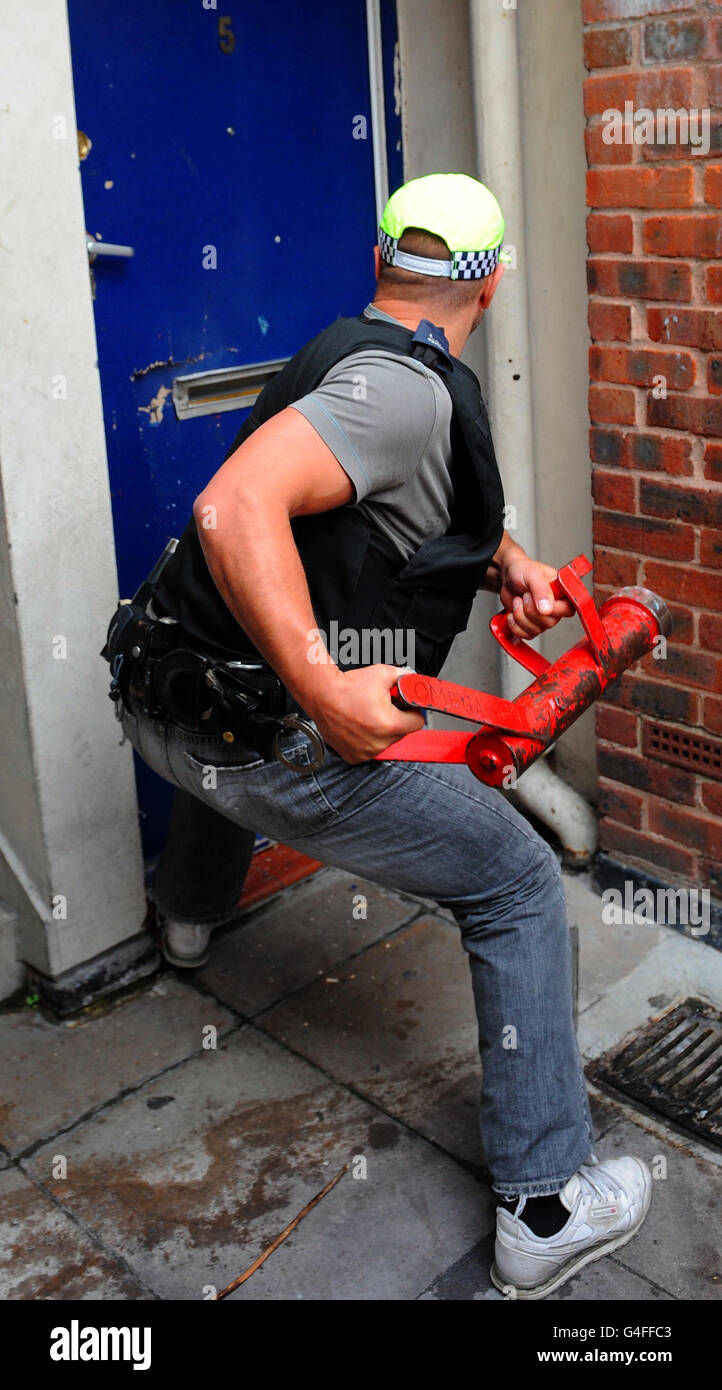 Officers smash the door of a property in Brixton with an enforcer as ...