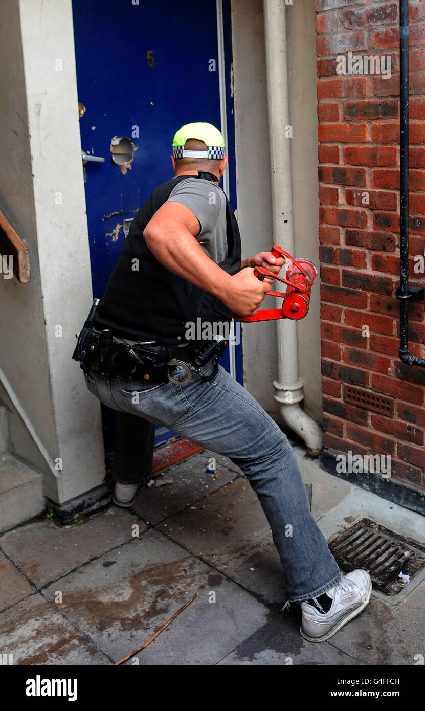 Officers smash the door of a property in Brixton with an enforcer as ...