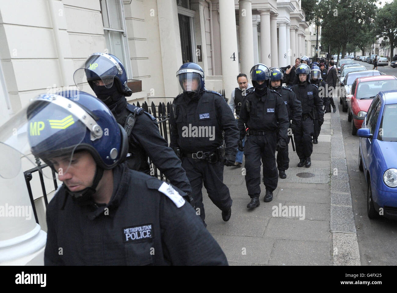 Metropolitan Police officers prepare to carry out a raid on a property ...