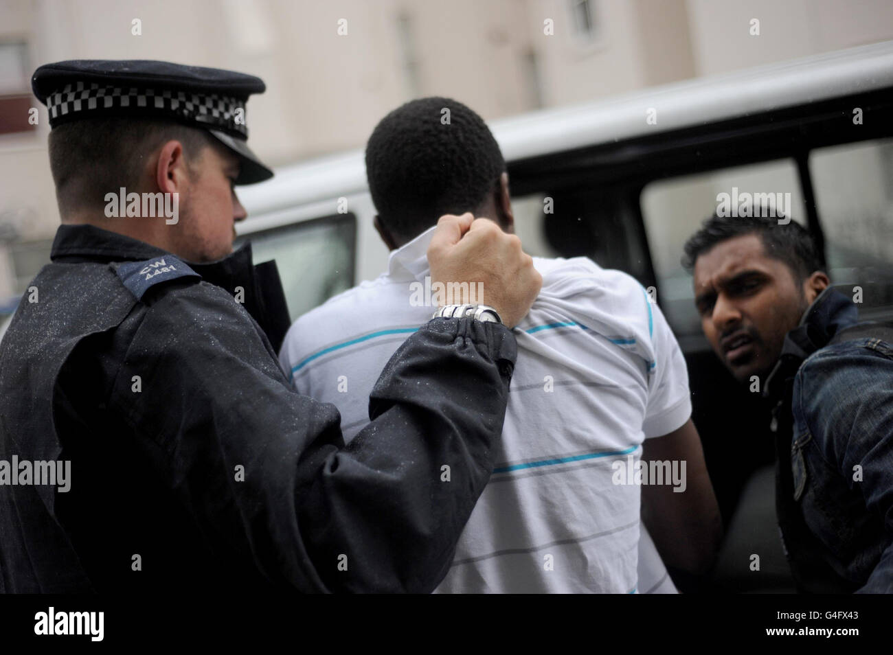 Metropolitan Police officers arrest a suspect after carrying out a raid ...