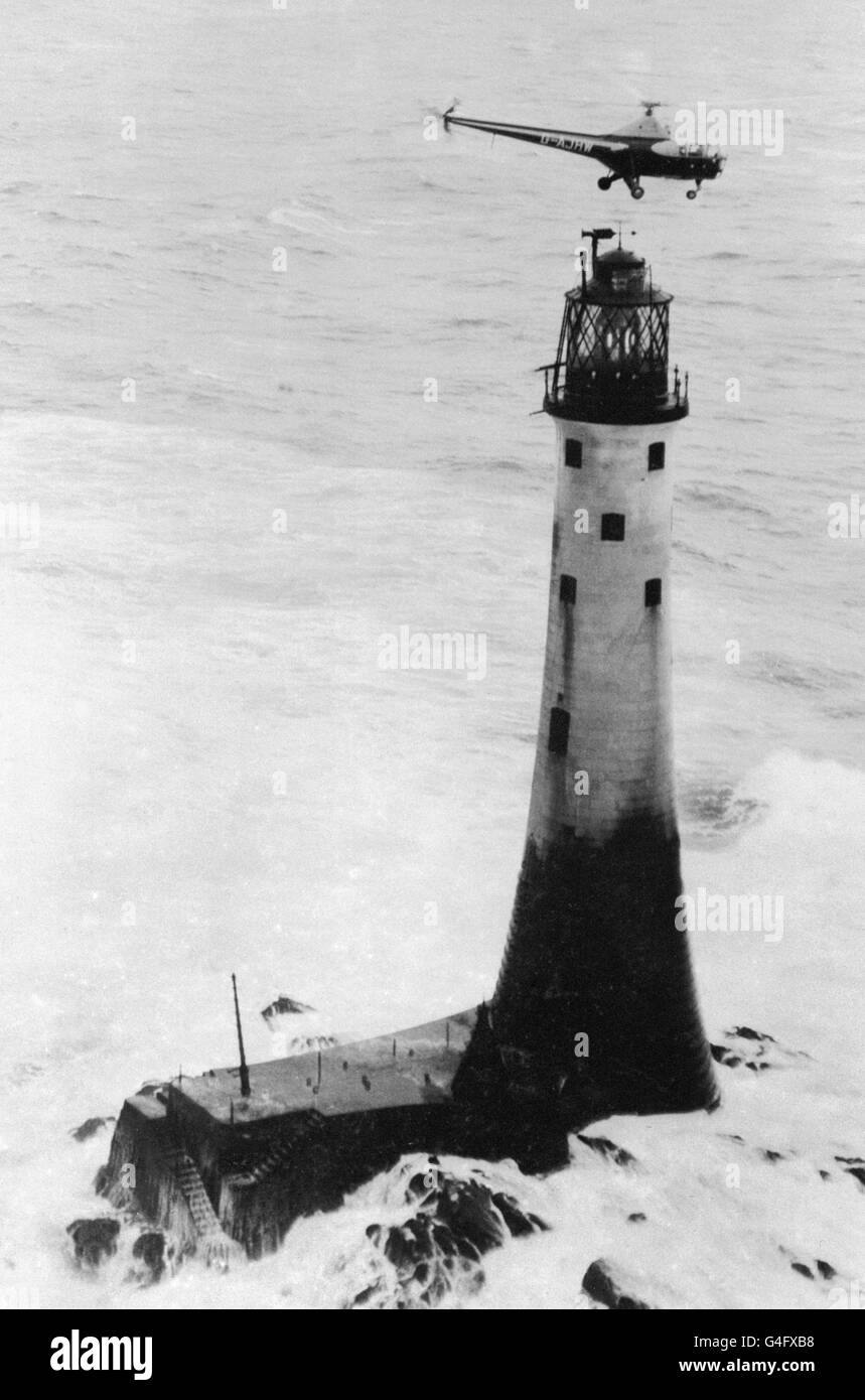 A helicopter hovers above wolf rock lighthouse hi-res stock photography ...