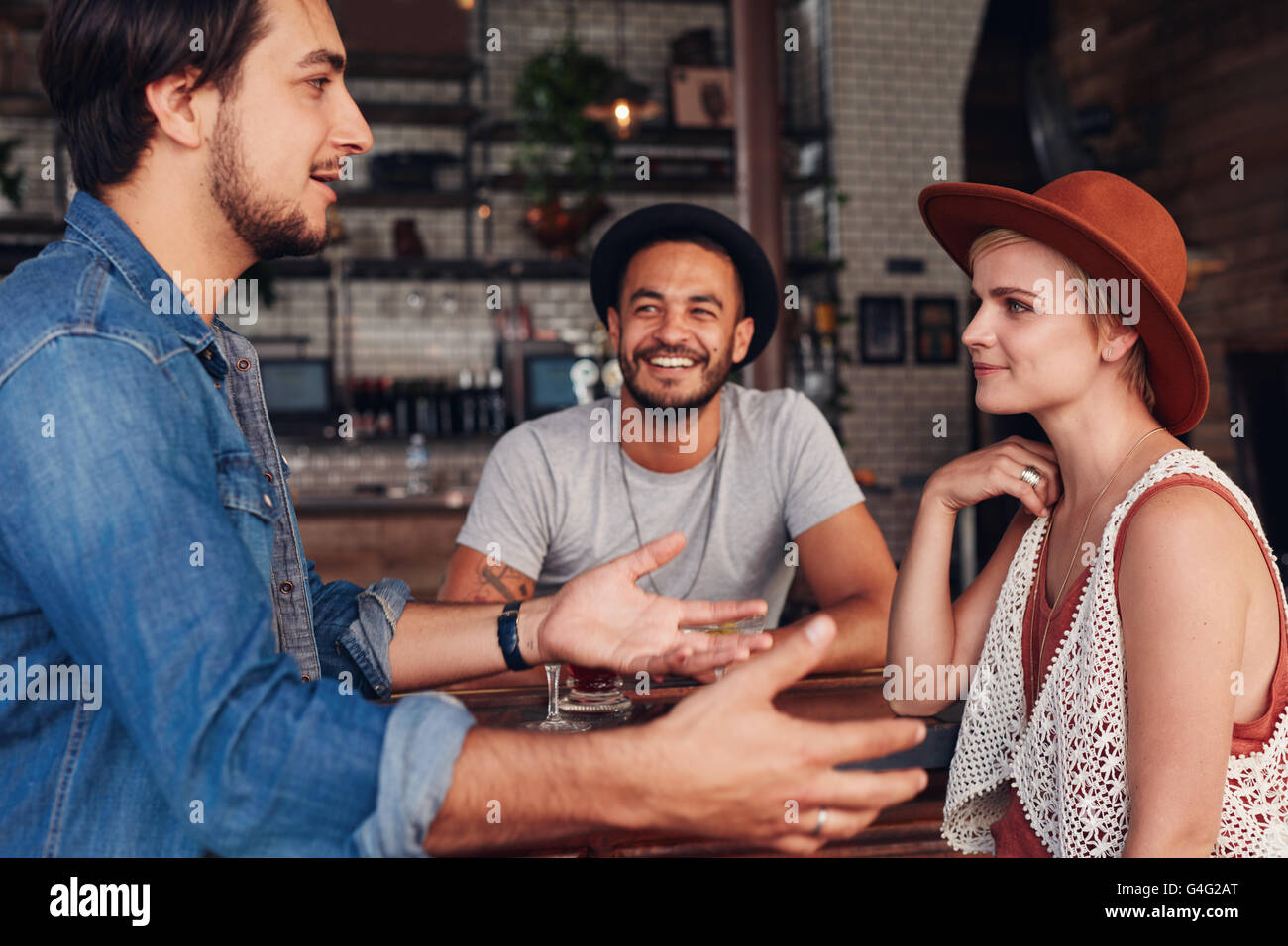 Group of young friends hanging out at a cafe. Young men and women ...