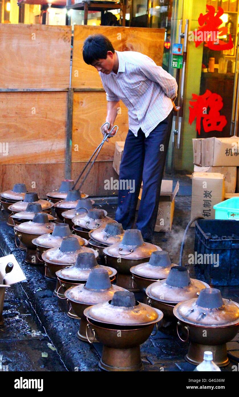 A worker cleaning the chimneys outside a Shanghai Hot Pot Restaurant ...