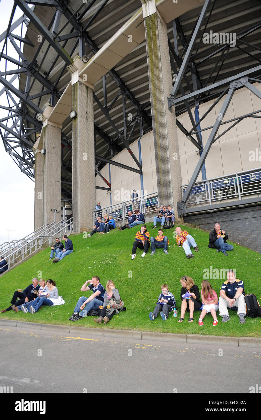 Fans sit on the grass outside of Murrayfield Stadium as they await to ...