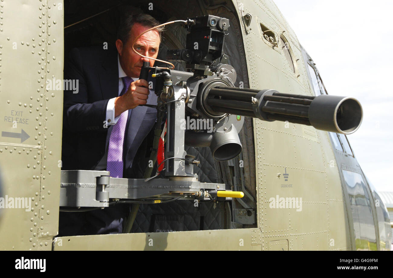 Defence Secretary Dr Liam Fox looks through the sights of a machine gun ...