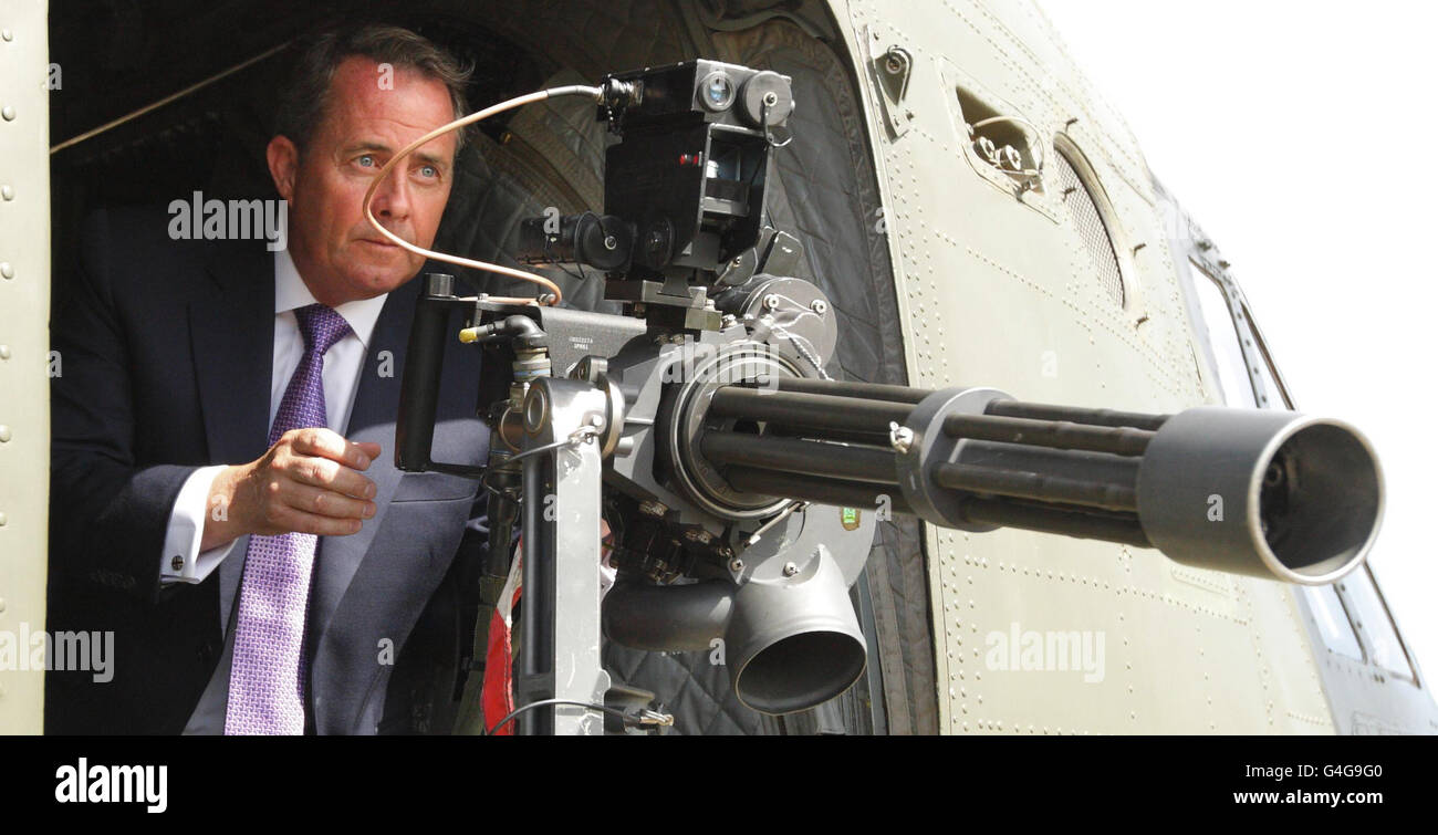 Defence Secretary Dr Liam Fox looks through the sights of a machine gun ...