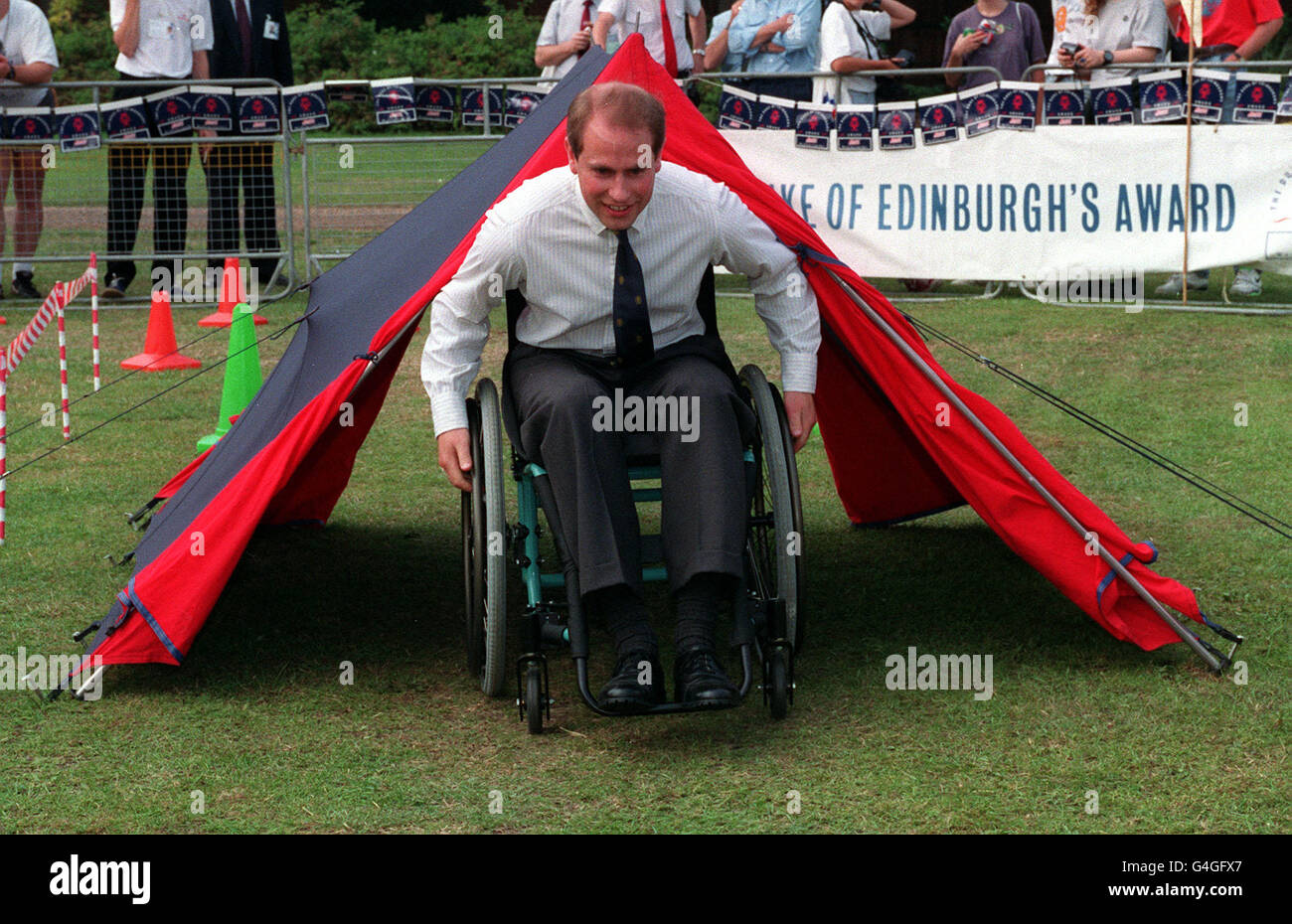 PA NEWS PHOTO 28/7/91 Prince Edward steers a wheelchair through a ...