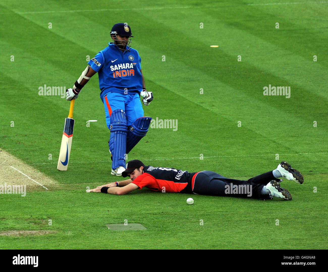 England's James Anderson (bottom) watches the ball go past him during ...