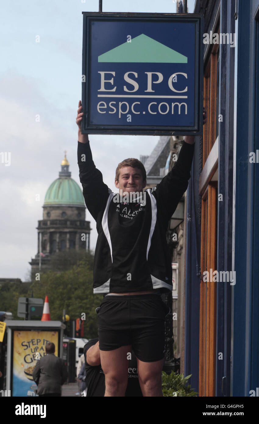 Edinburgh's Stuan Dewar holds on to the ESPC sign during a sponsorship ...