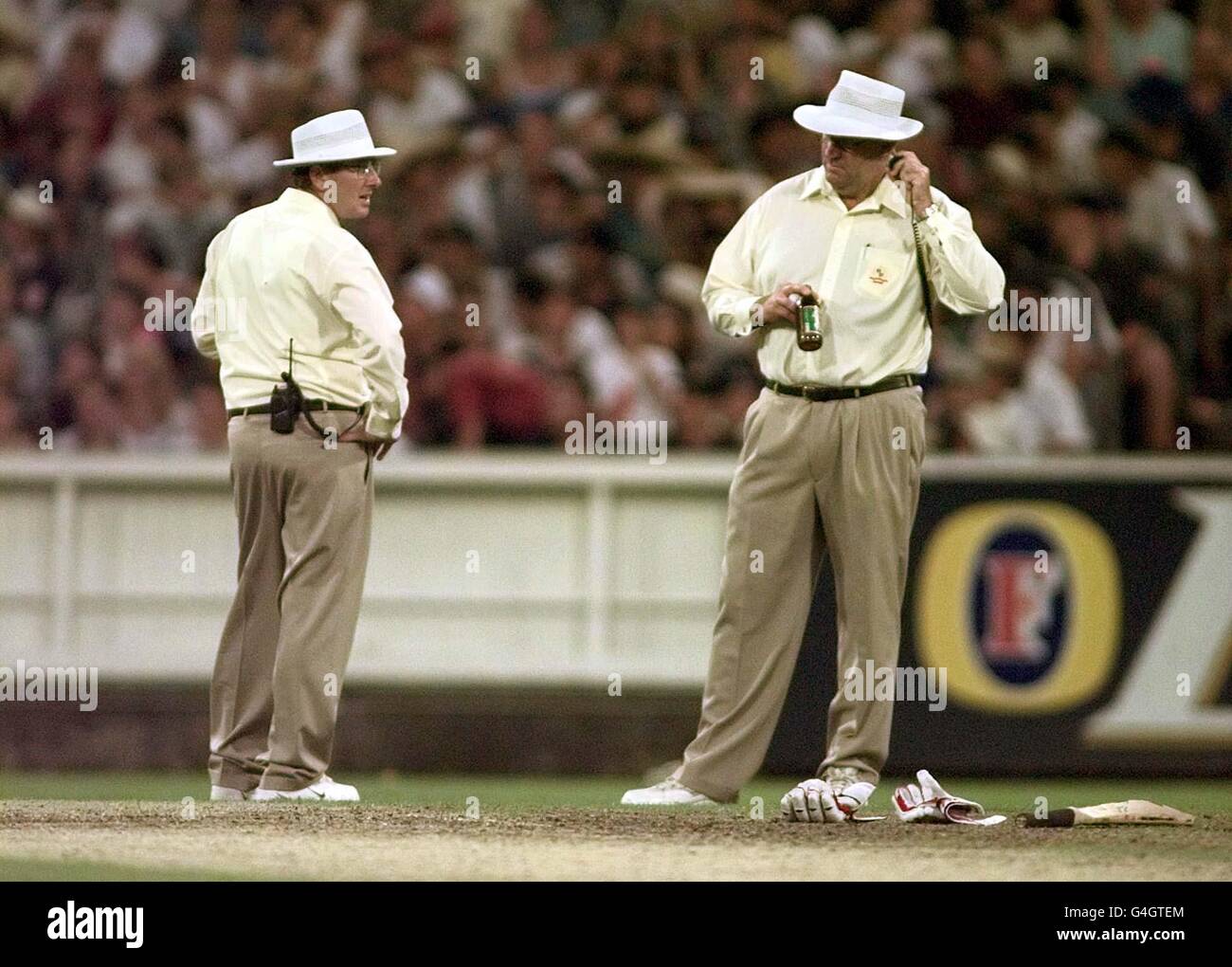 Umpire Darrell Hair (r) listens to his radio whilst holding a bottle of ...