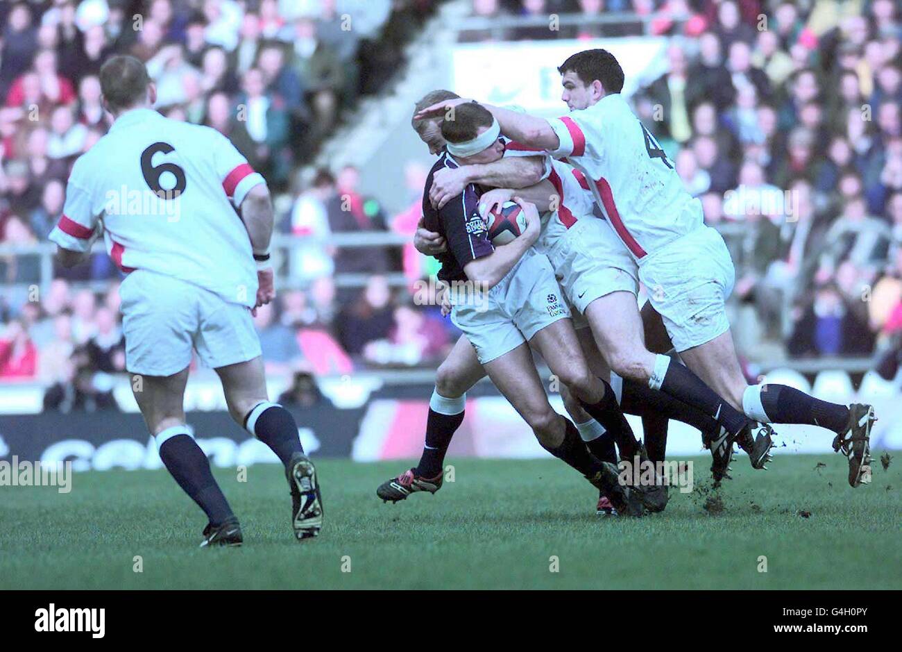 Scotland's Stuart Grimes (centre) is tackled by England's Tim Rodber ...