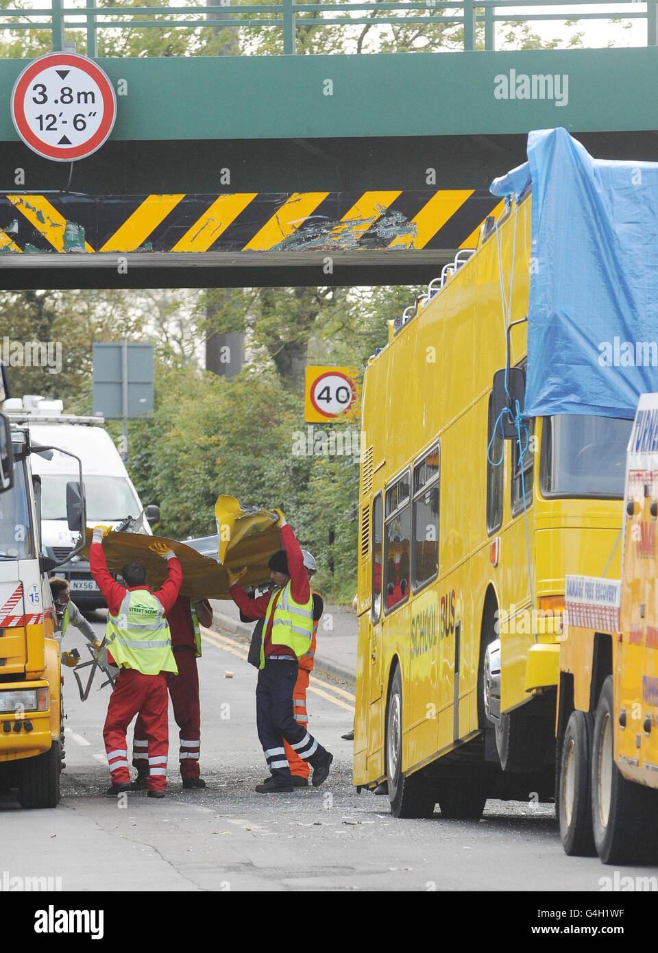 A double decker bus is recovered from underneath a railway bridge in ...