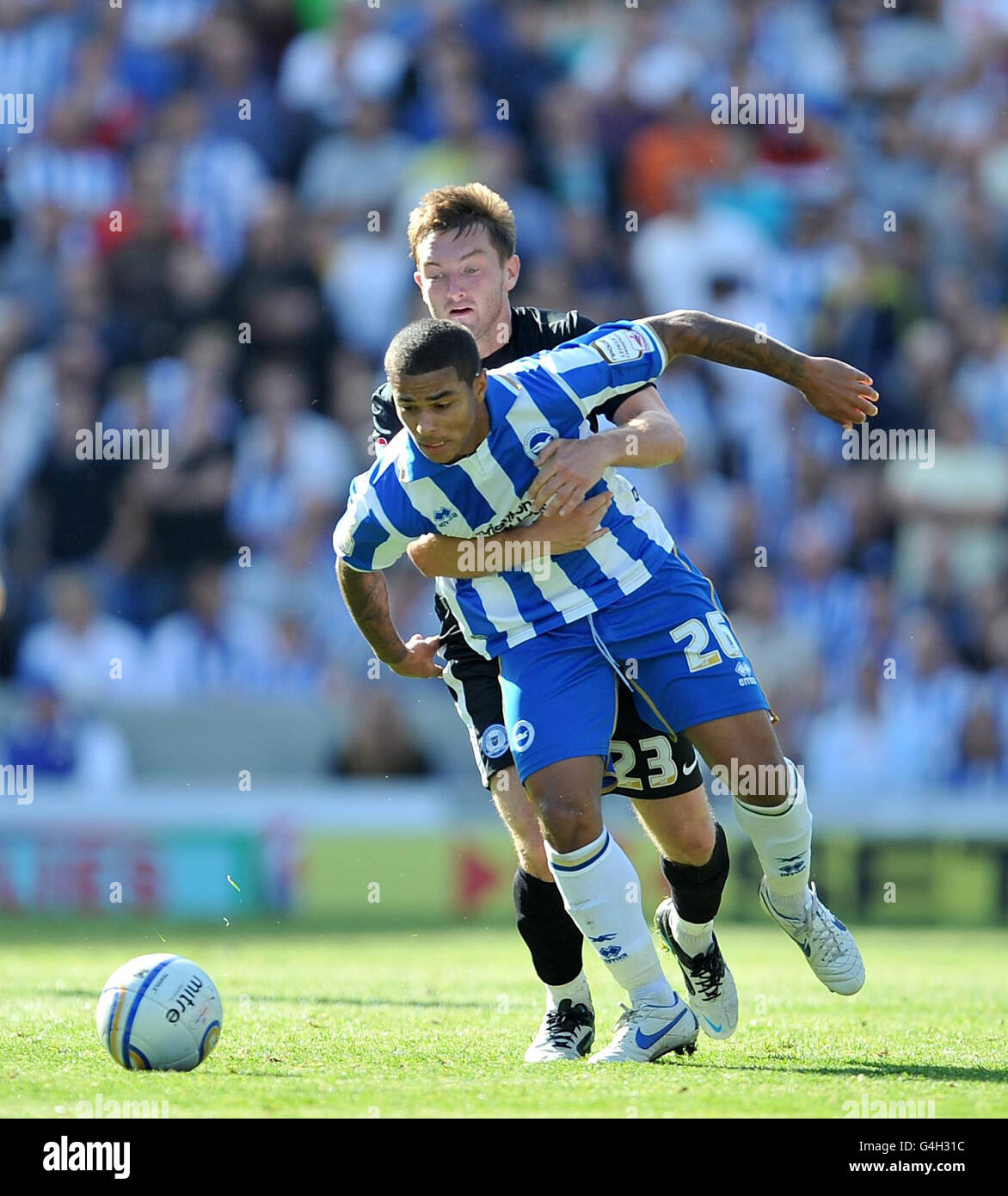 Brighton and Hove Albion's Liam Bridcutt (front) shields the ball from ...