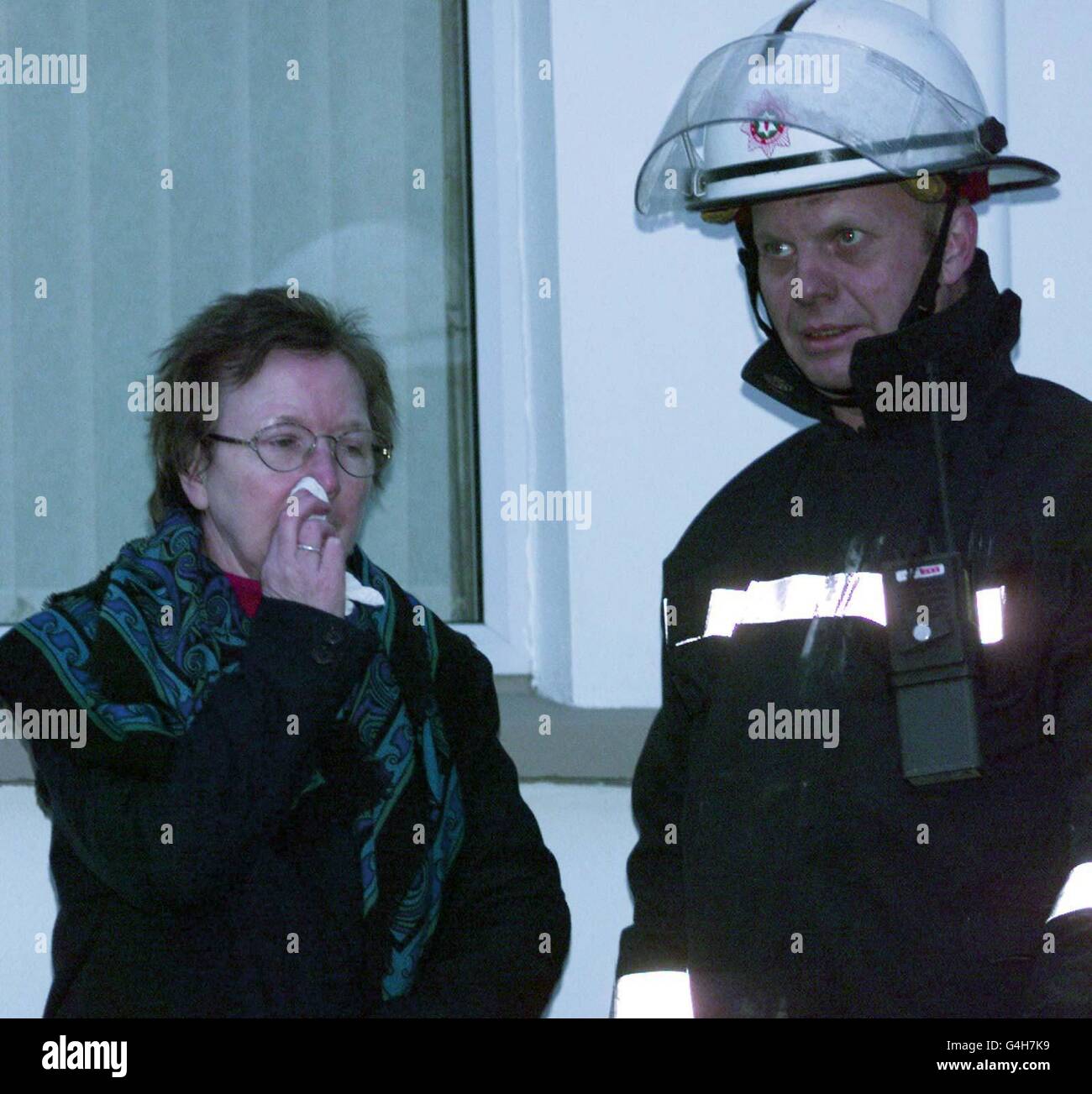 A Shocked Neighbour With A Fireman At The Scene Of The House Fire In a-shocked-neighbour-with-a-fireman-at-the-scene-of-the-house-fire-in