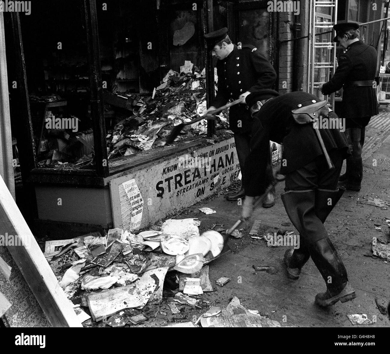 Firemen help to clear up damage after an incendiary device caused havoc ...