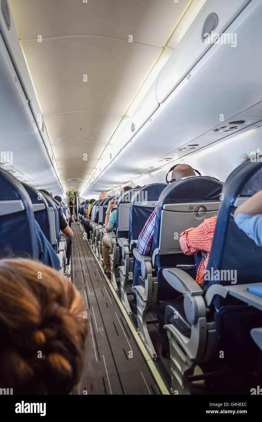 plane inside cabin with passengers, passengers on board Stock Photo - Alamy