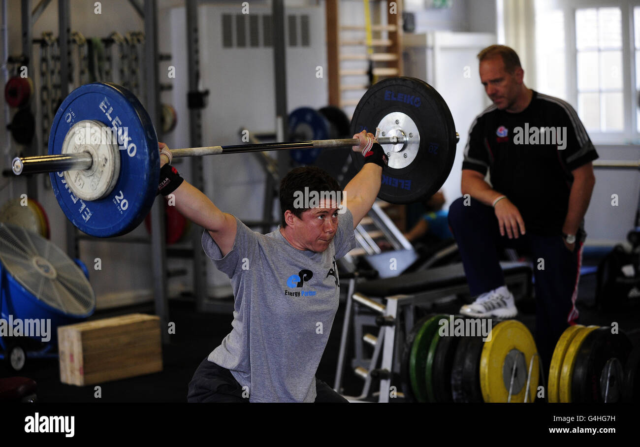 Weightlifter Natashe Perdue is watched by coach Tamas Feher as she ...