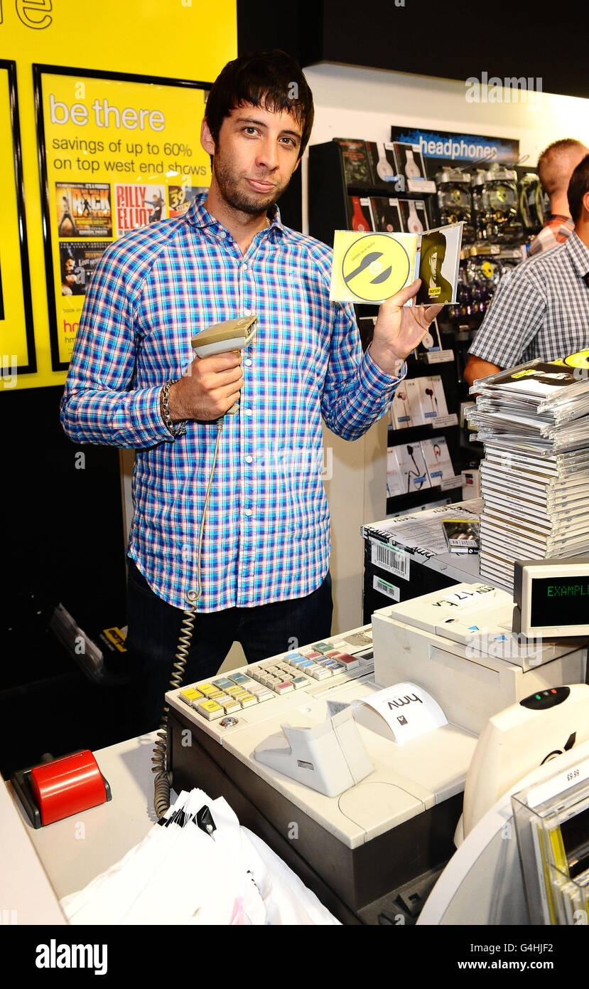 Example serves behind the till and signs copies of his new album ...