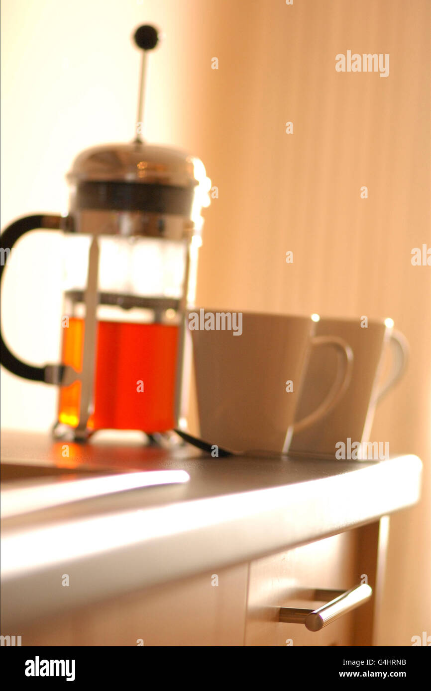 Kitchen set up with cafetiere of coffee brewing and two mugs on the ...