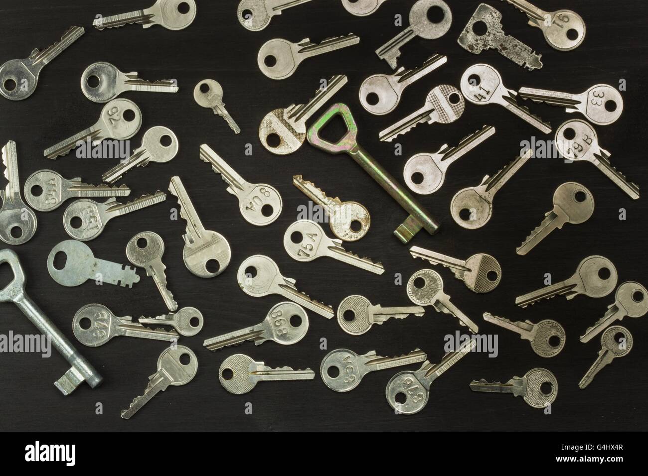 Silver Keys and color on dark wooden board. Different types of keys ...