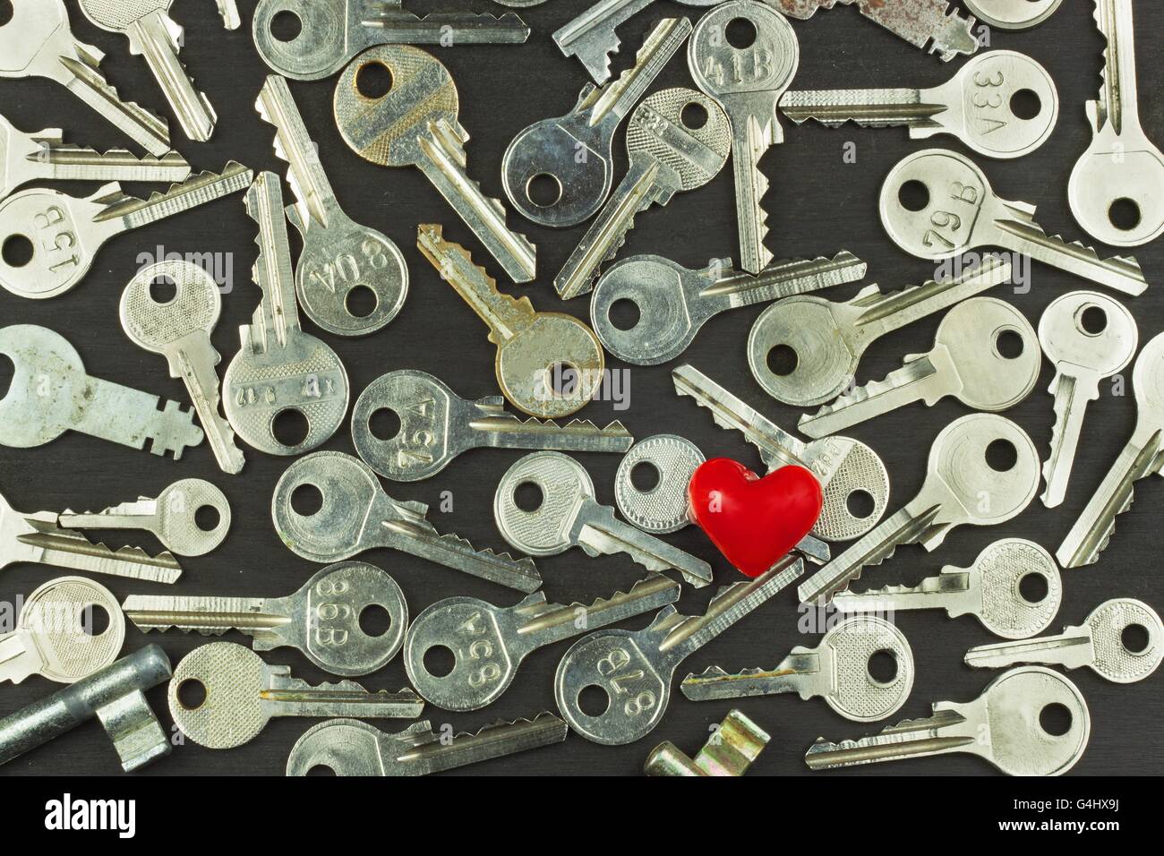 Silver Keys and color on dark wooden board. Different types of keys ...