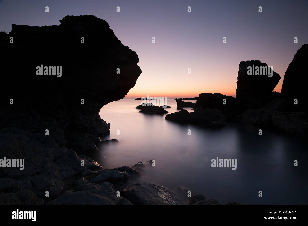 Dramatic craggy rocks in silhouette at dusk Godrevy Rocks Stock Photo ...