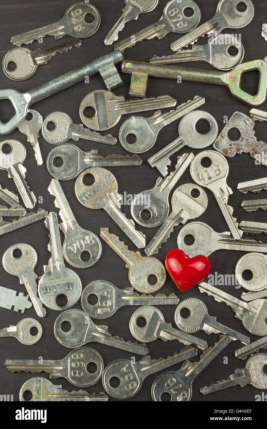 Silver Keys and color on dark wooden board. Different types of keys ...