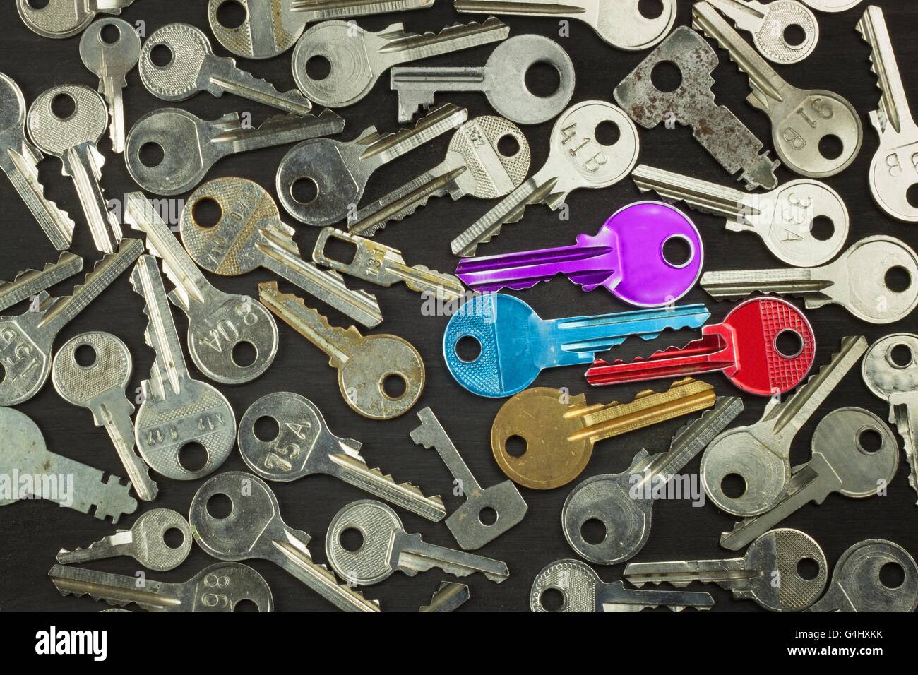 Silver Keys and color on dark wooden board. Different types of keys ...